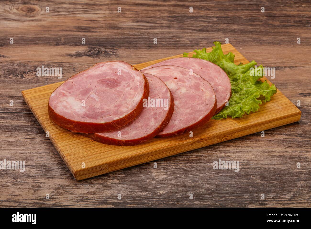 Slices of pork meat ham over wooden board Stock Photo - Alamy