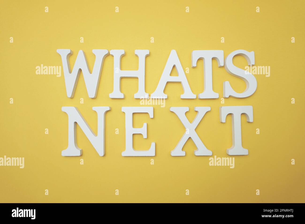 Whats Next alphabet letter on yellow background Stock Photo - Alamy