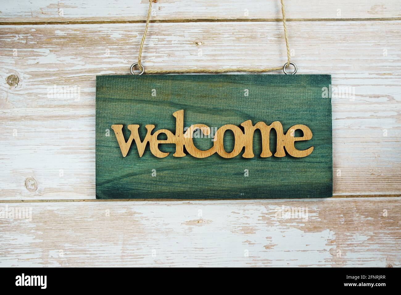 Welcome sign hanging on wooden background Stock Photo - Alamy