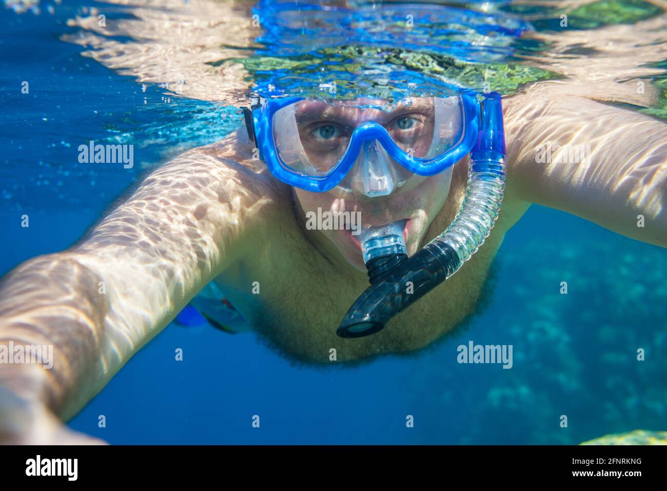 Snorkeling man underwater giving in blue sea Stock Photo - Alamy