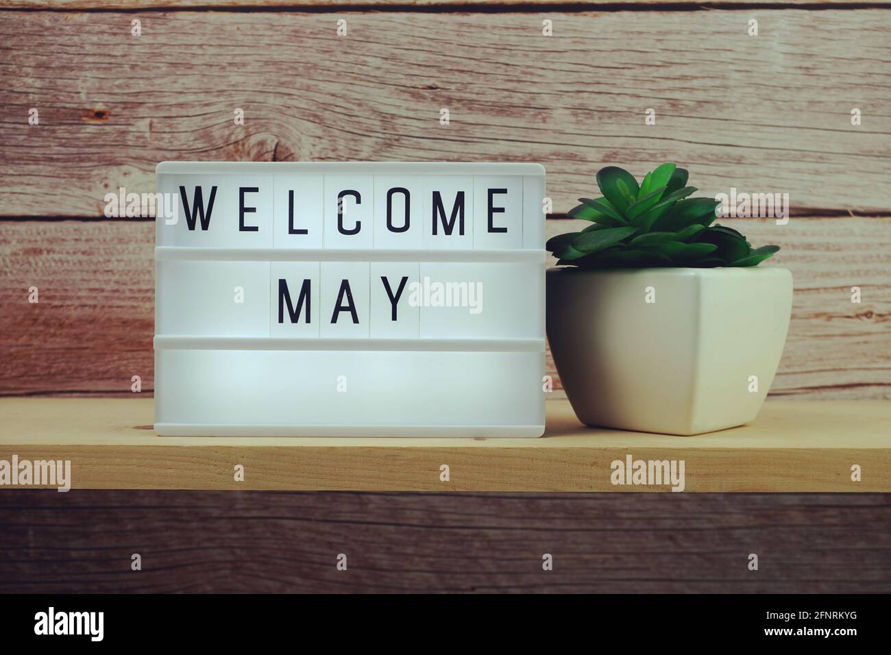 Welcome May word in light box on wooden shelves background Stock Photo ...