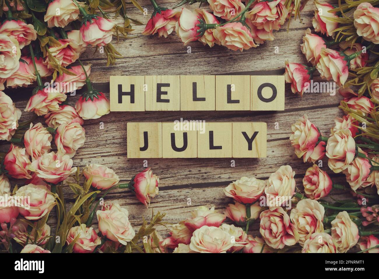 Hello July alphabet letters with flower decoration on wooden background ...