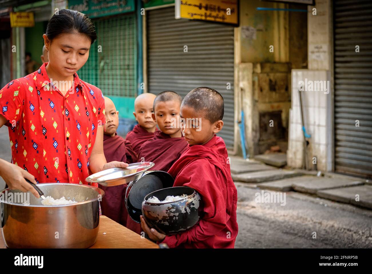 Food being gifted to young monks in the streets of Yangon Stock Photo ...