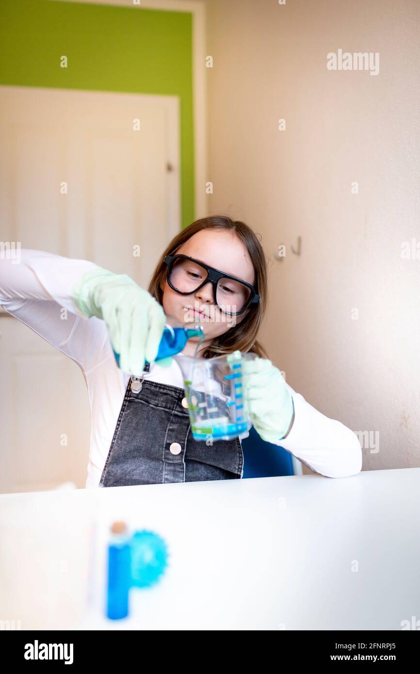 pretty young schoolgirl sitting on her desk in room at home ...