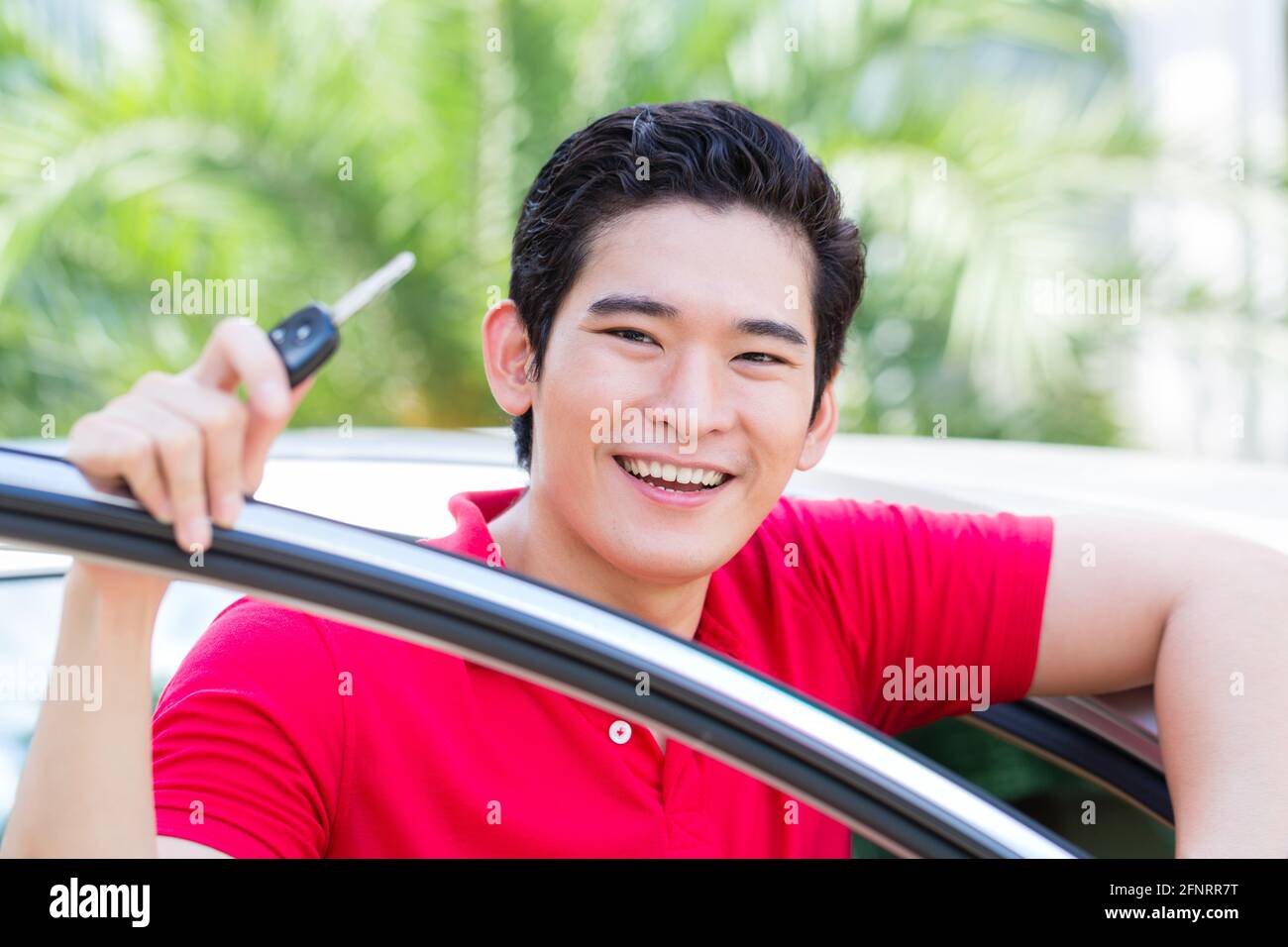 Asian man showing key of his new car Stock Photo - Alamy