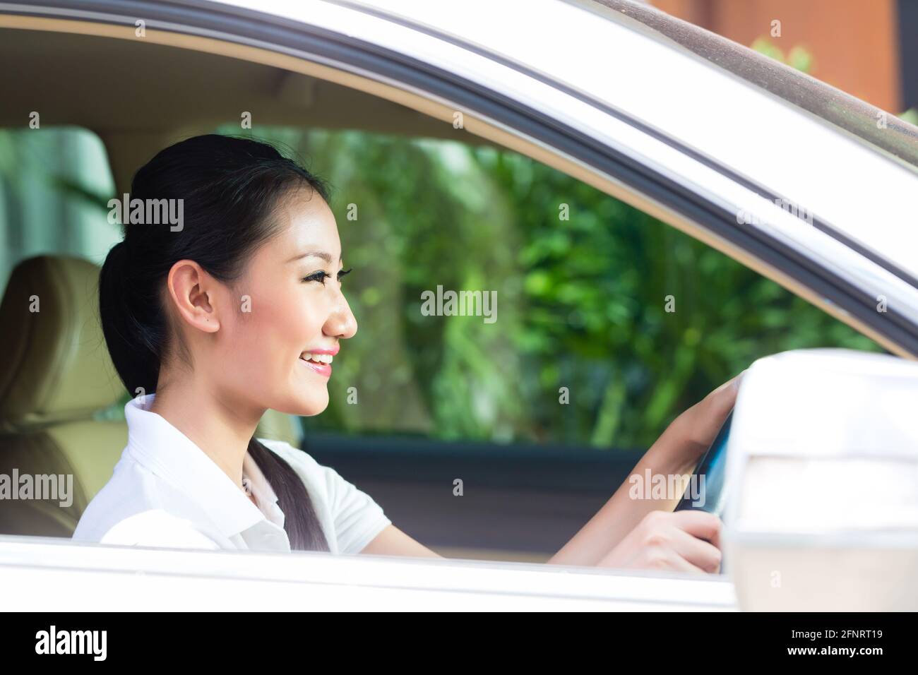 Asian woman driving new car Stock Photo - Alamy