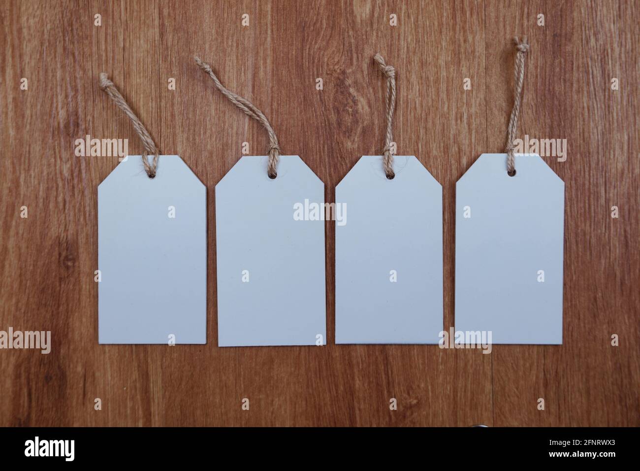 four white tags with copy space Top view on wooden background Stock ...