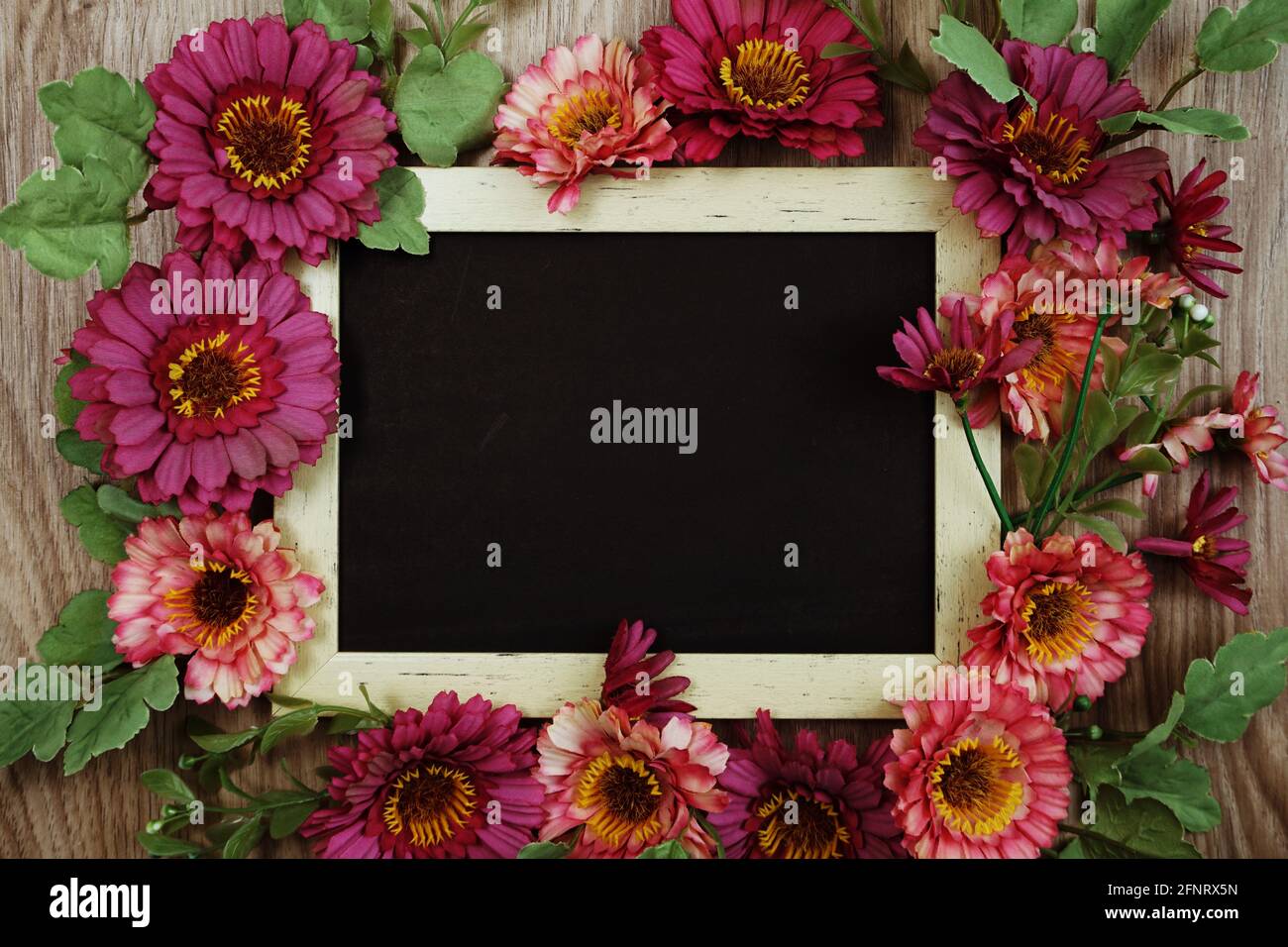 Flat lay of flowers and space copy black board on wooden background ...
