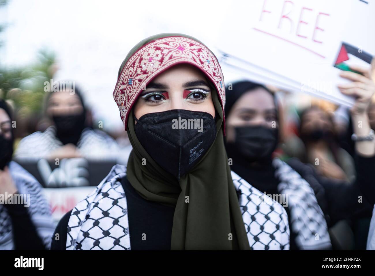 Woman wearing traditional Palestinian clothing paints her eyes with the ...