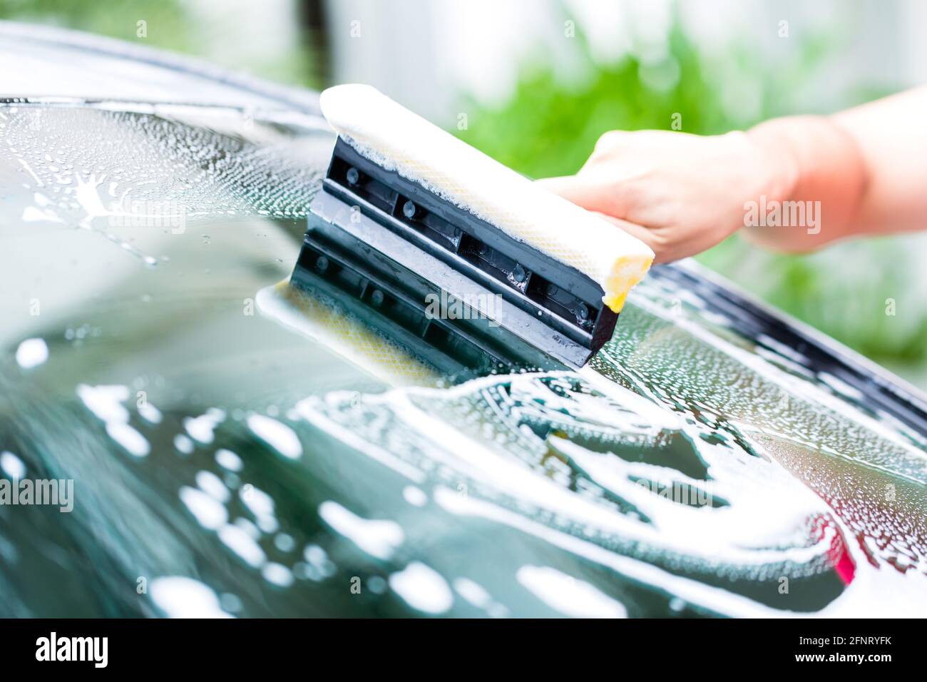 man cleaning windscreen while car wash Stock Photo - Alamy