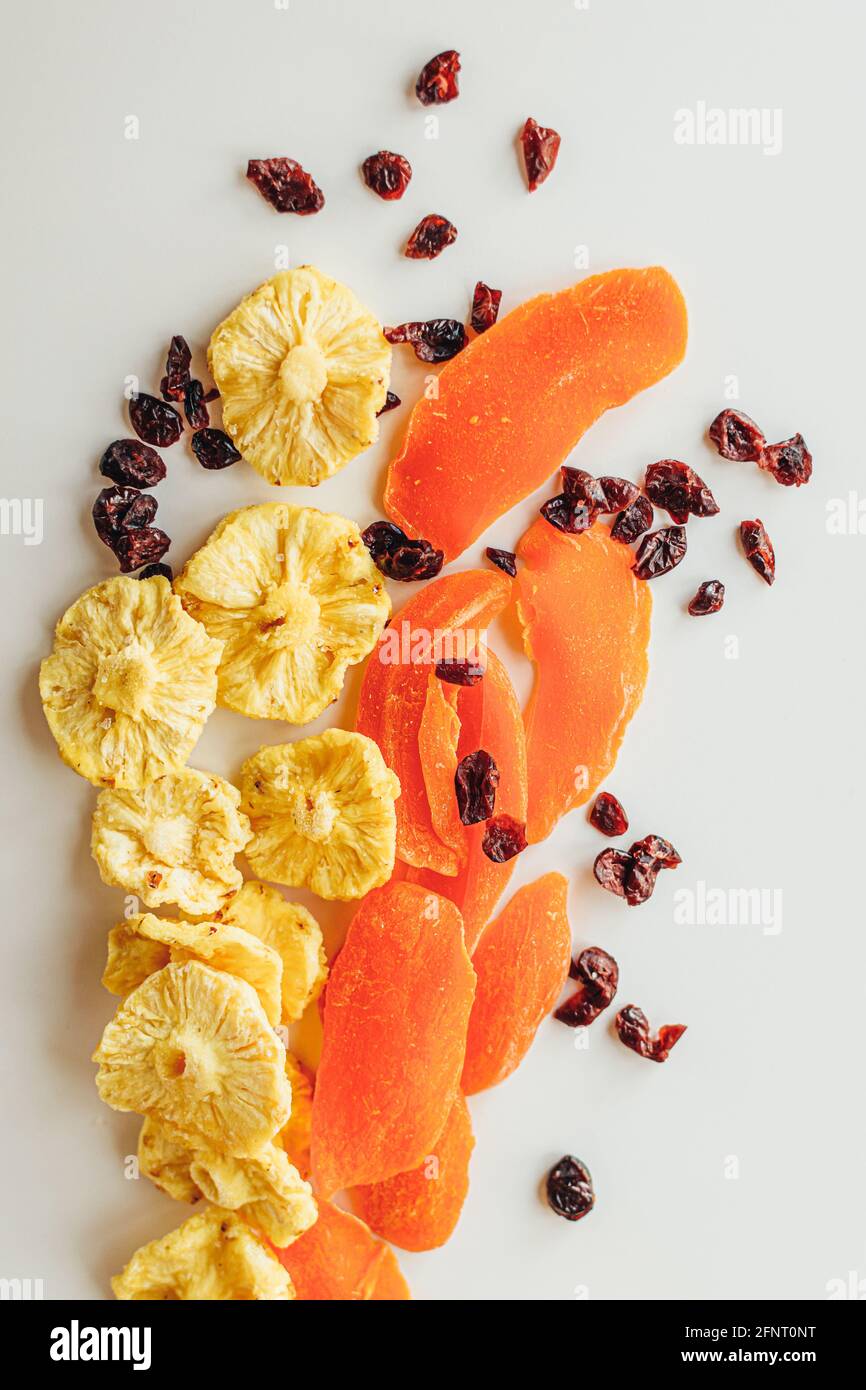 Mixed dry fruits on the light background. Pineapple, mango and ...