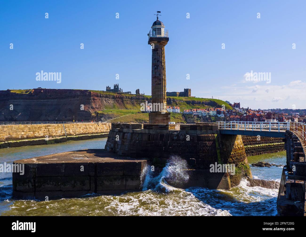 Whitby Lighthouse with the Abbey ruins and the Church of St Mary in the ...