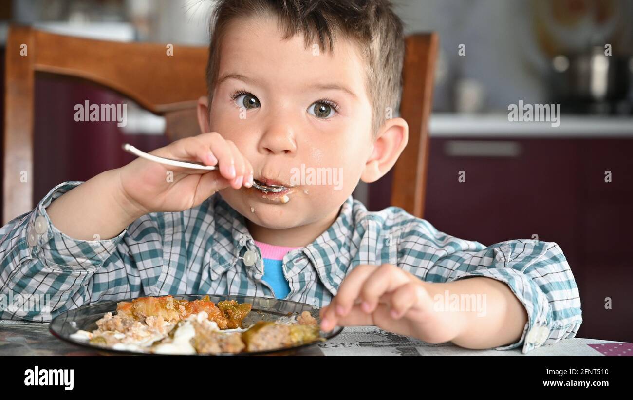 Child in shirt eating close up Stock Photo - Alamy