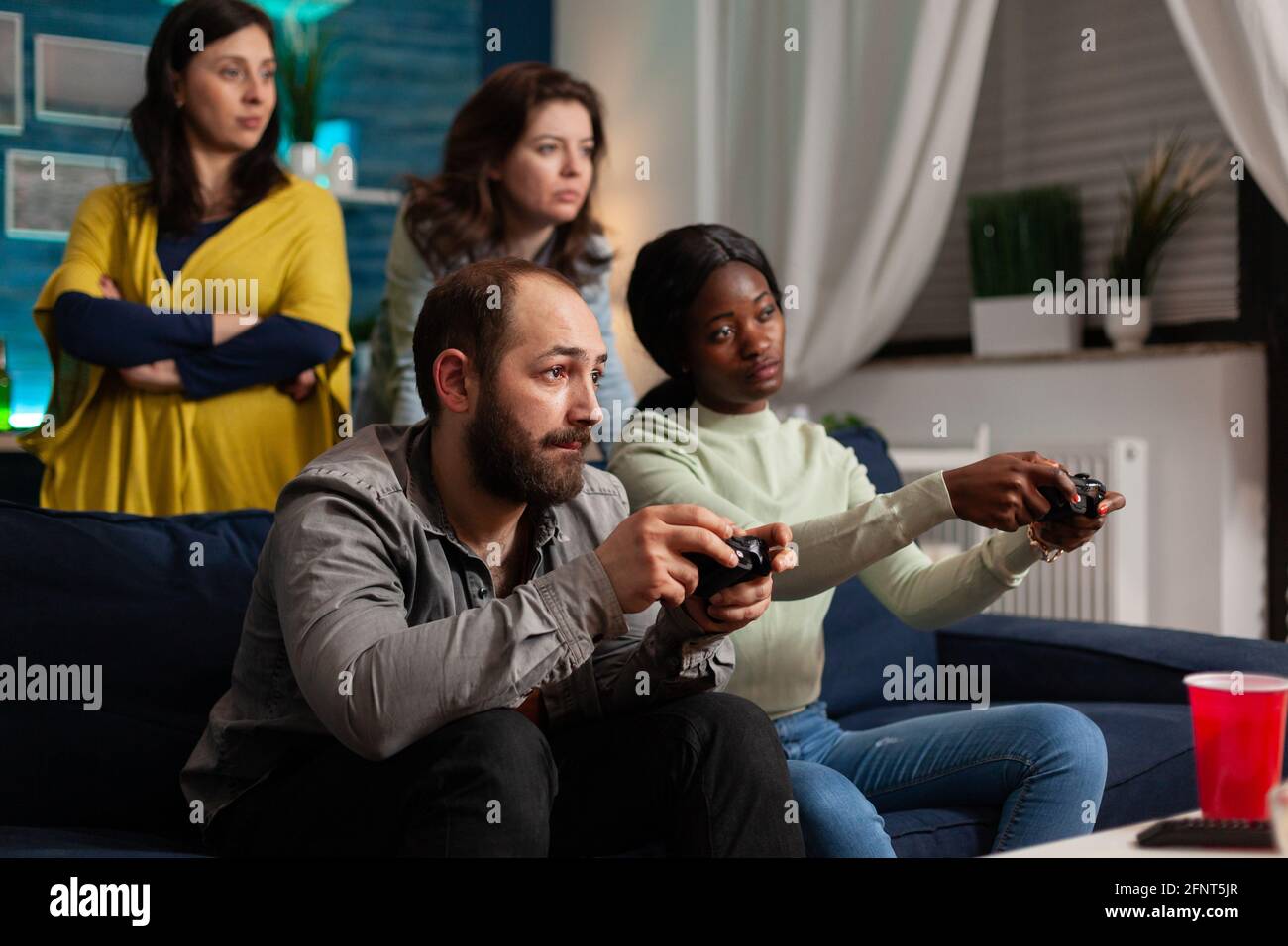 Man playing video games with multi ethnic friends using wireless ...