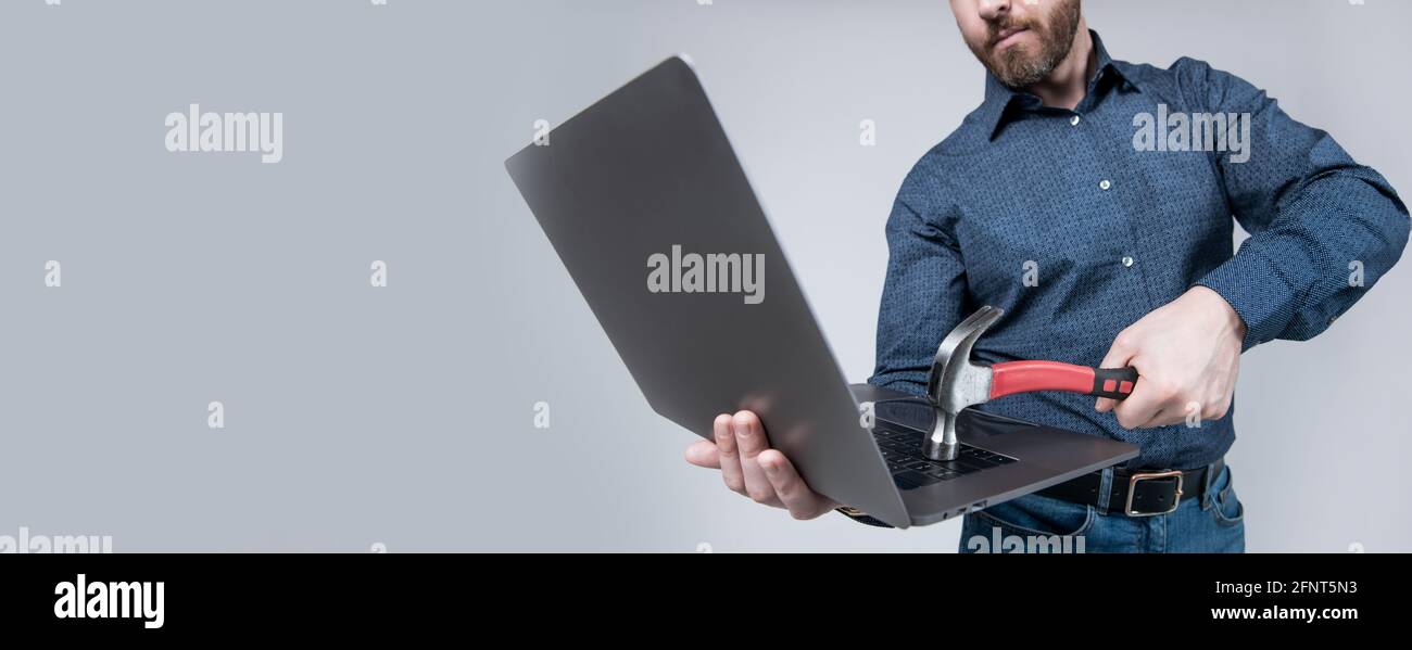 Bearded man cropped view beat with hammer breaking into computer grey ...