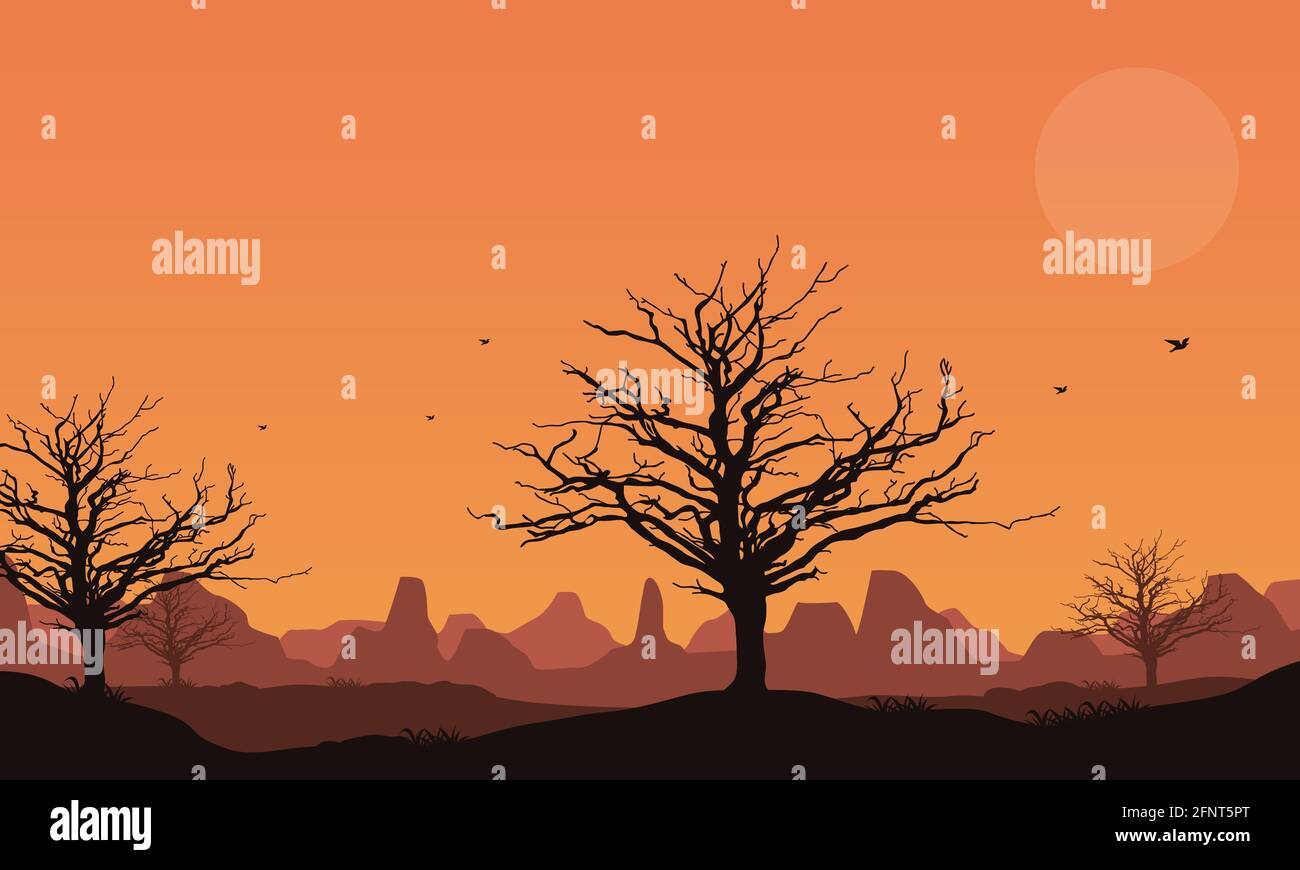 Wonderful view of the mountains with silhouettes of dry trees at dusk ...