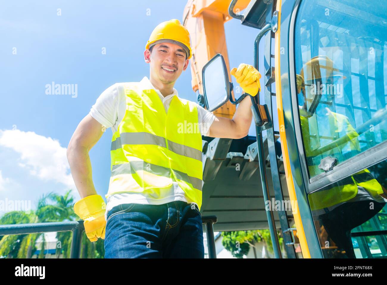 Asian driver standing on construction machinery on building site Stock ...