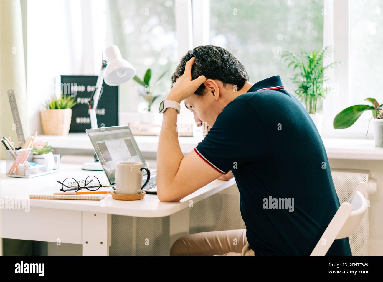 Business man holding his head work in a laptop Stock Photo - Alamy