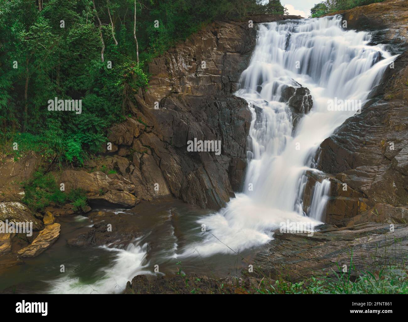 Small waterfall flowing through the river rocks, low shutter speed ...