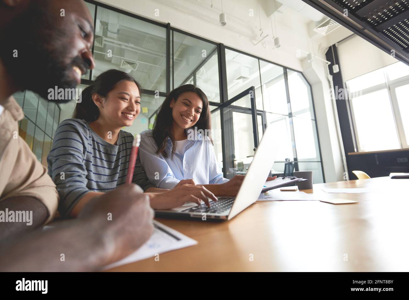 Three friendly coworkers looking at computer screen Stock Photo - Alamy