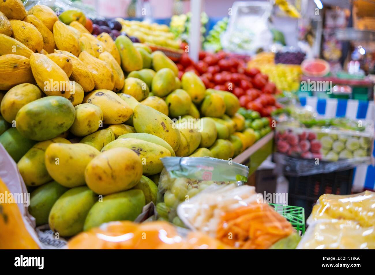 Colorful fruit stand with green and yellow mangoes, and more Stock ...