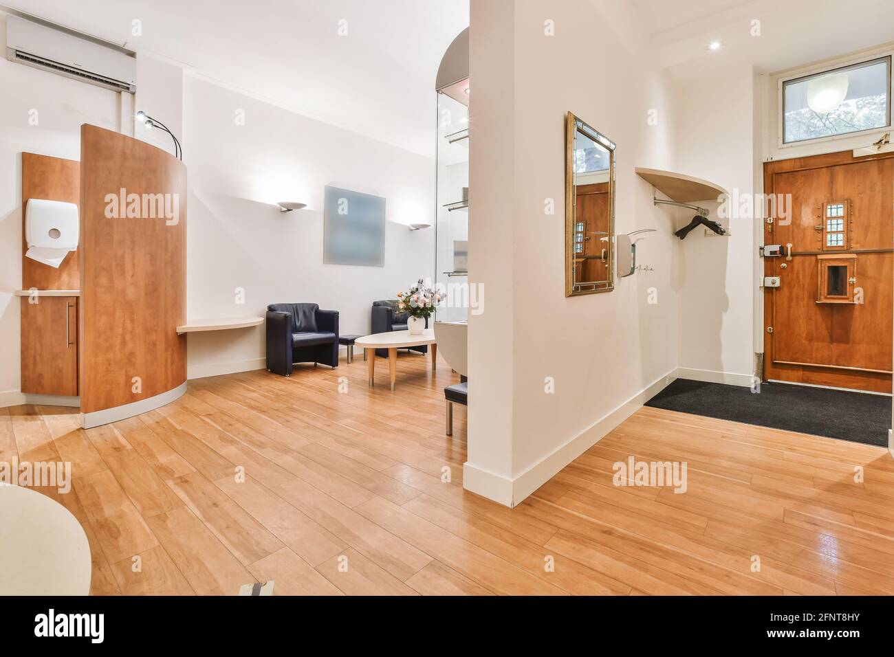 Sink with mirror and toiletries located in front of partition in lobby ...
