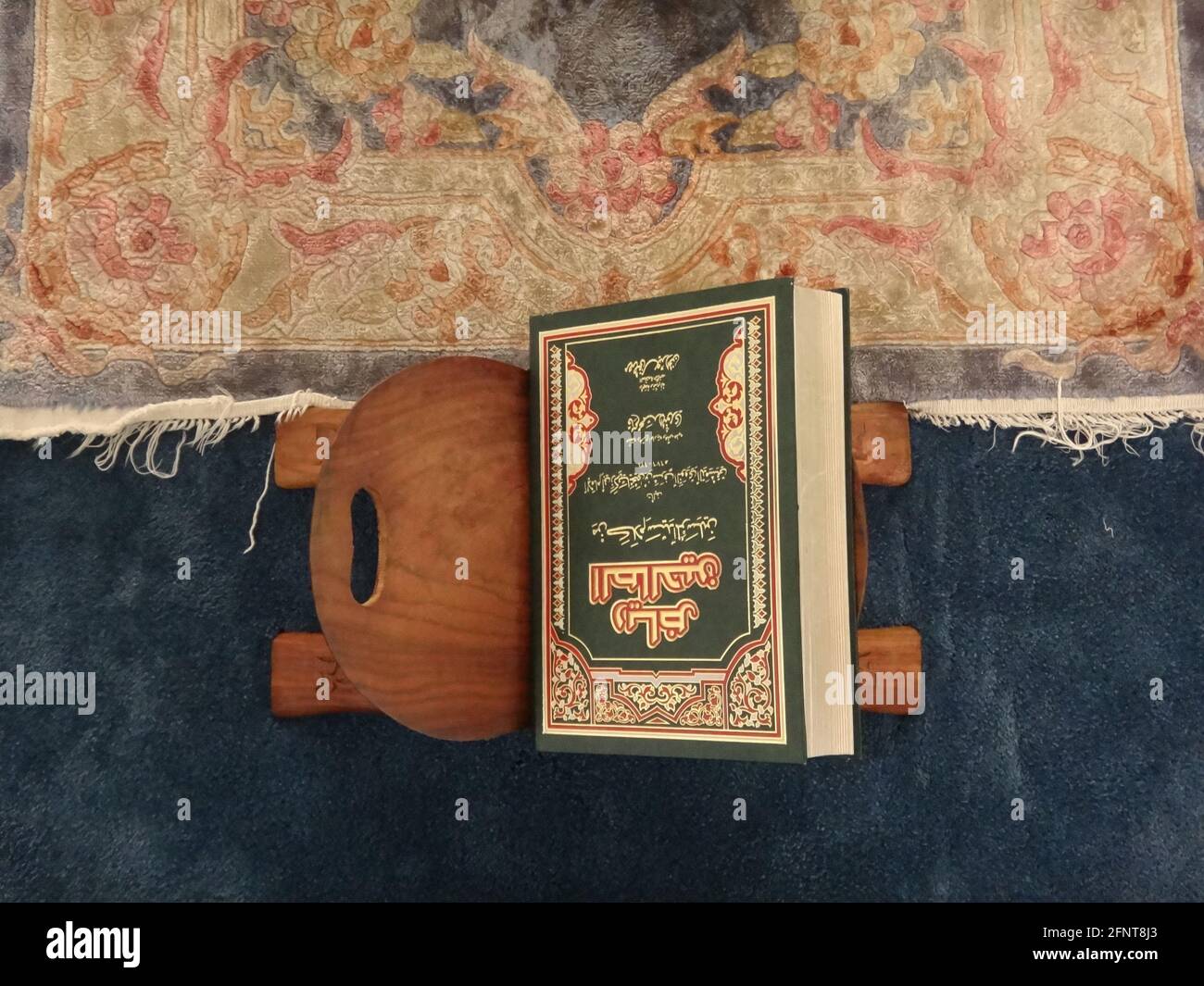 CARACAS, VENEZUELA - Dec 19, 2012: a Quran and a carpet on the floor ...