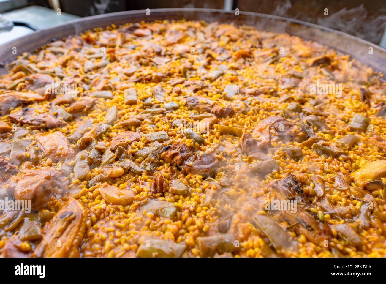 Valencian paella made of rice, chicken, rabbit and vegetables during ...