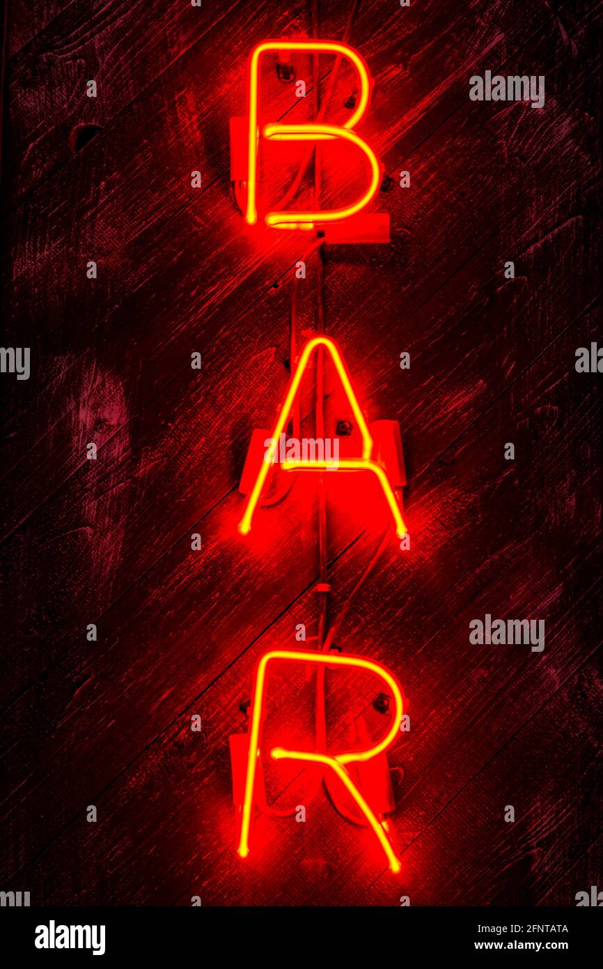 Glowing Neon red sign BAR on wooden background. Dark tones vintage ...