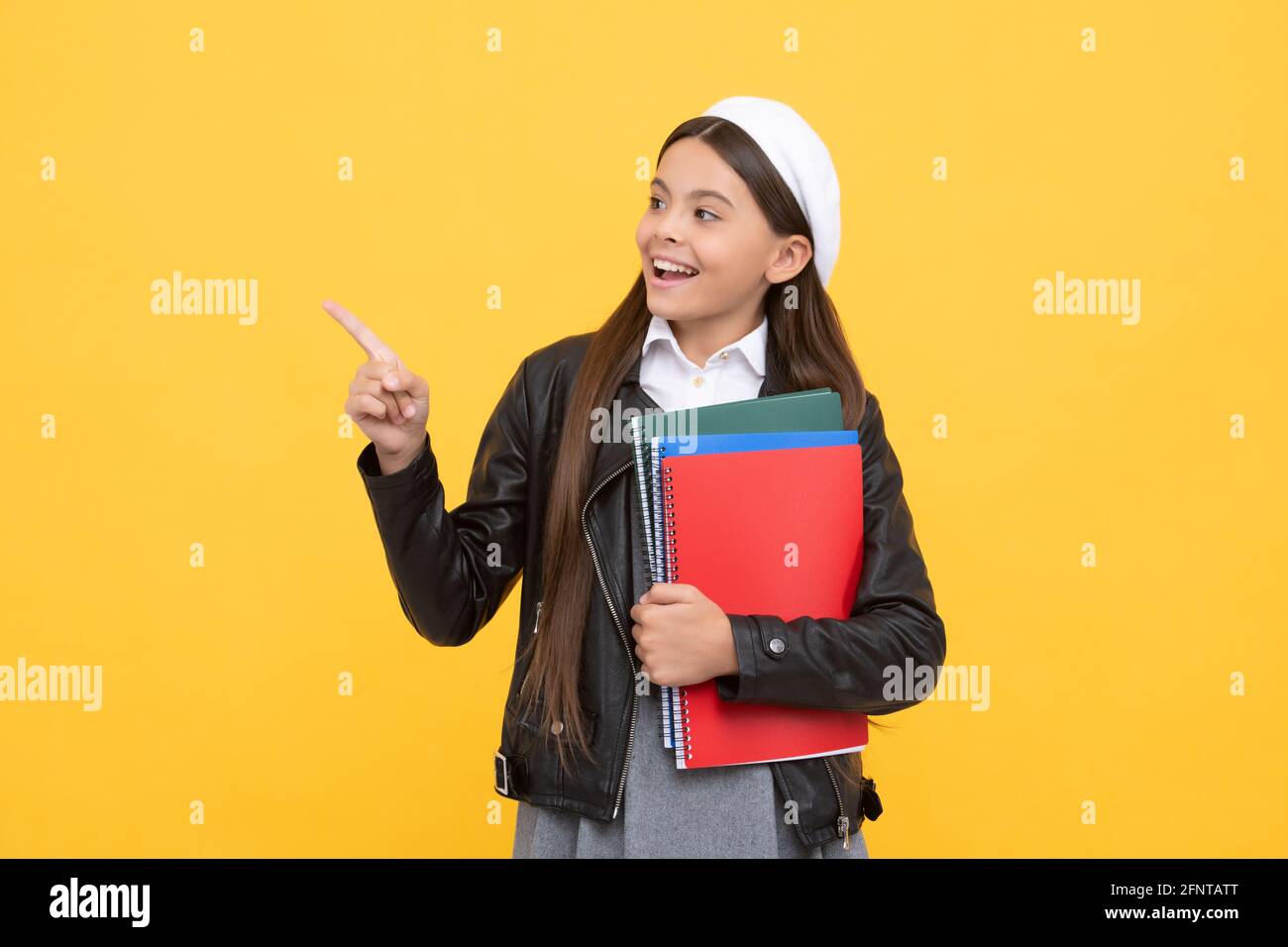 Look. Happy school child point finger yellow background. Pointing ...
