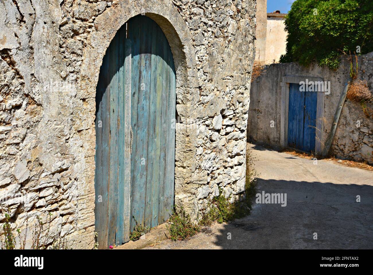 Old rural stone houses with antique wooden doors in Aroniadika village ...