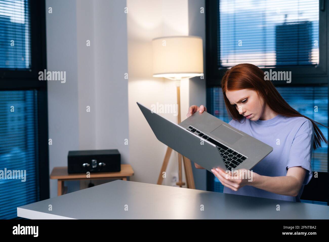 Frustrated young woman confused by laptop computer problem sitting at ...