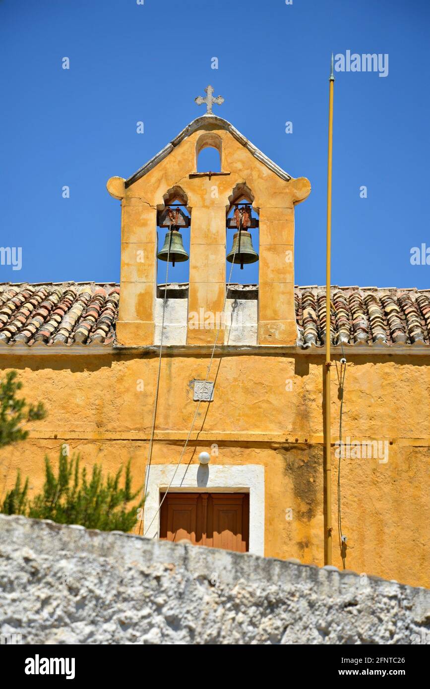 Traditional Greek Orthodox church ochre facade with a clay tile rooftop ...