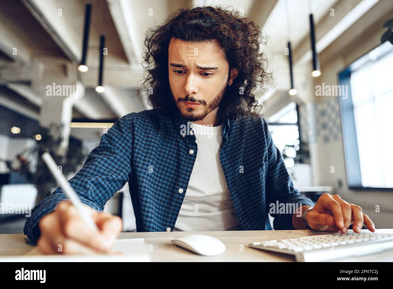 Handsome curly man writing notes hi-res stock photography and images ...