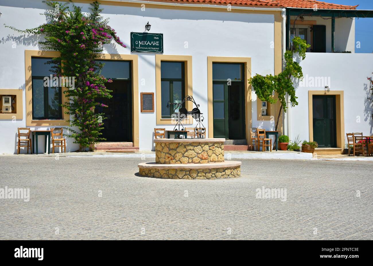 Traditional Greek taverna facade with a whitewashed wall, green wooden ...