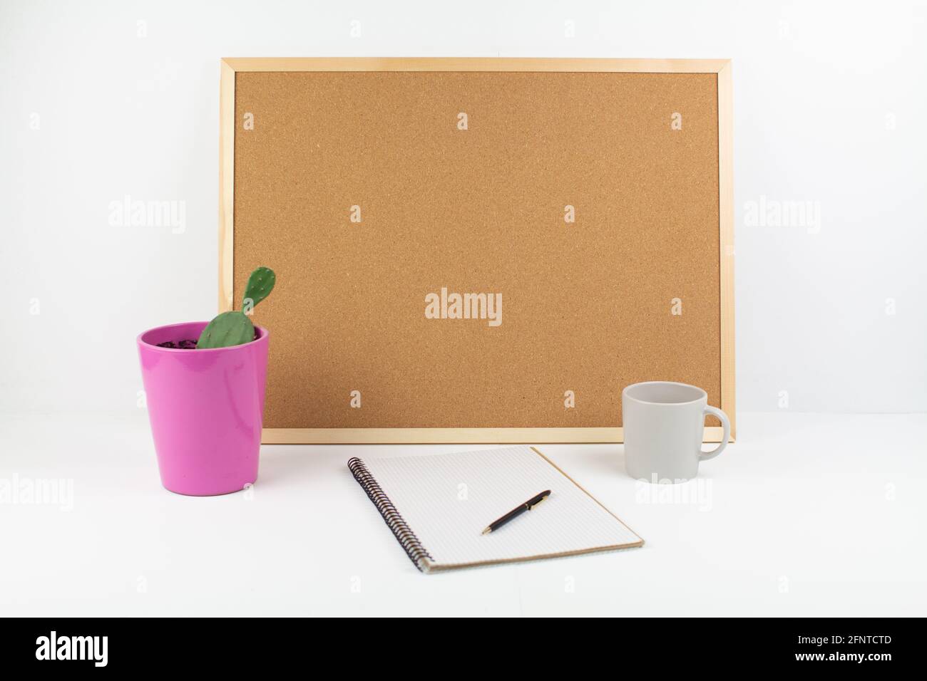 a cork board for notes on white background with pen and notepad in ...