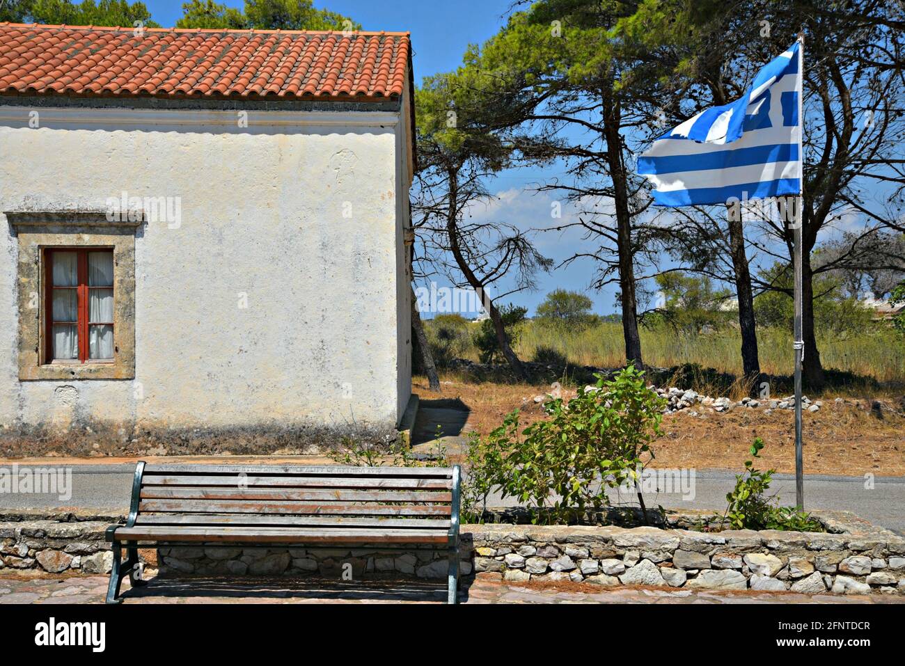 Old municipal building with the weaving Greek flag on the foreground in ...
