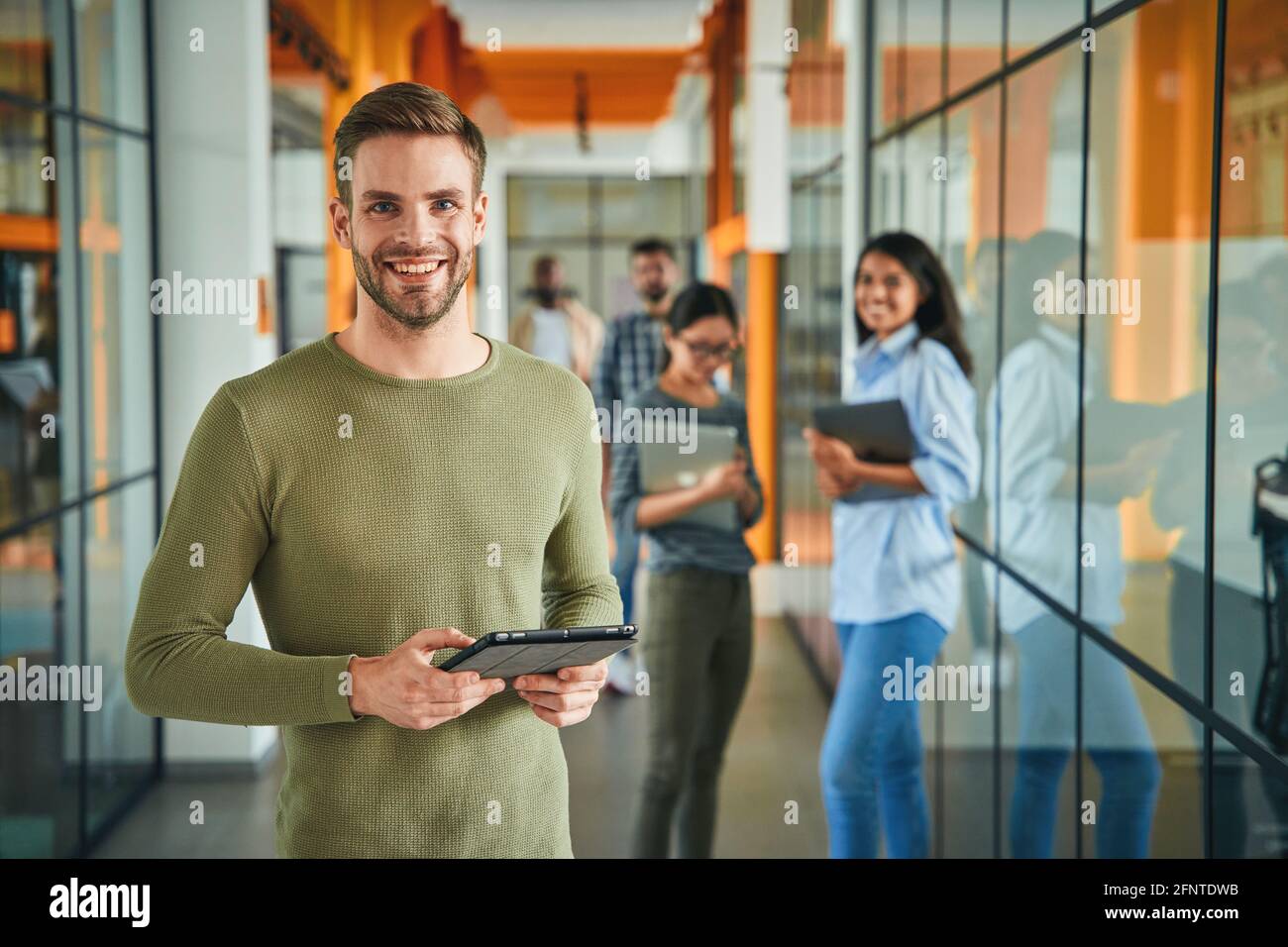 Handsome young man with welcoming smile posing for camera Stock Photo ...