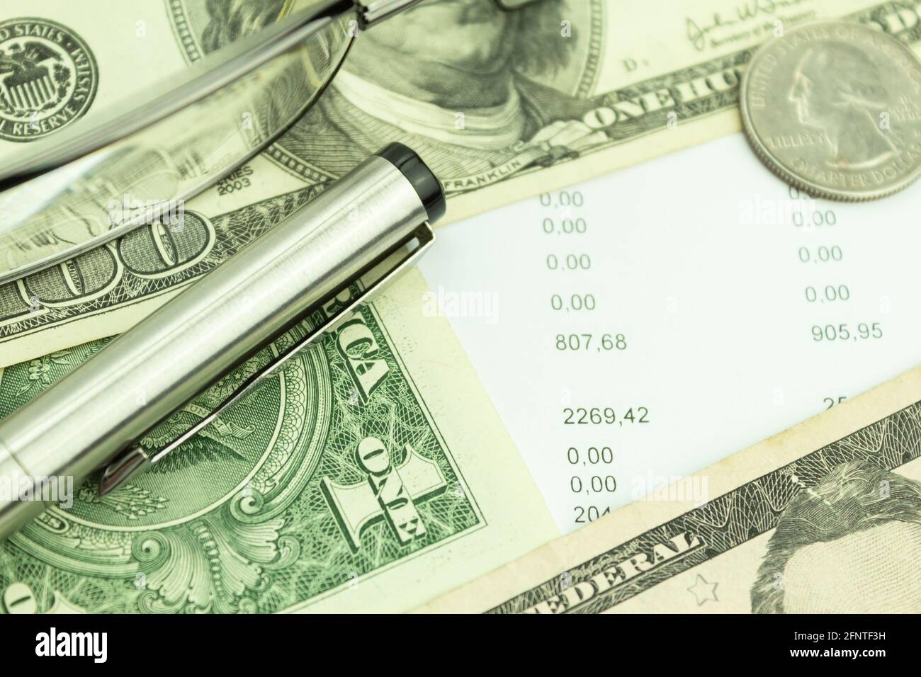 Dollar banknotes and glasses on the table. Forms with numbers on the ...