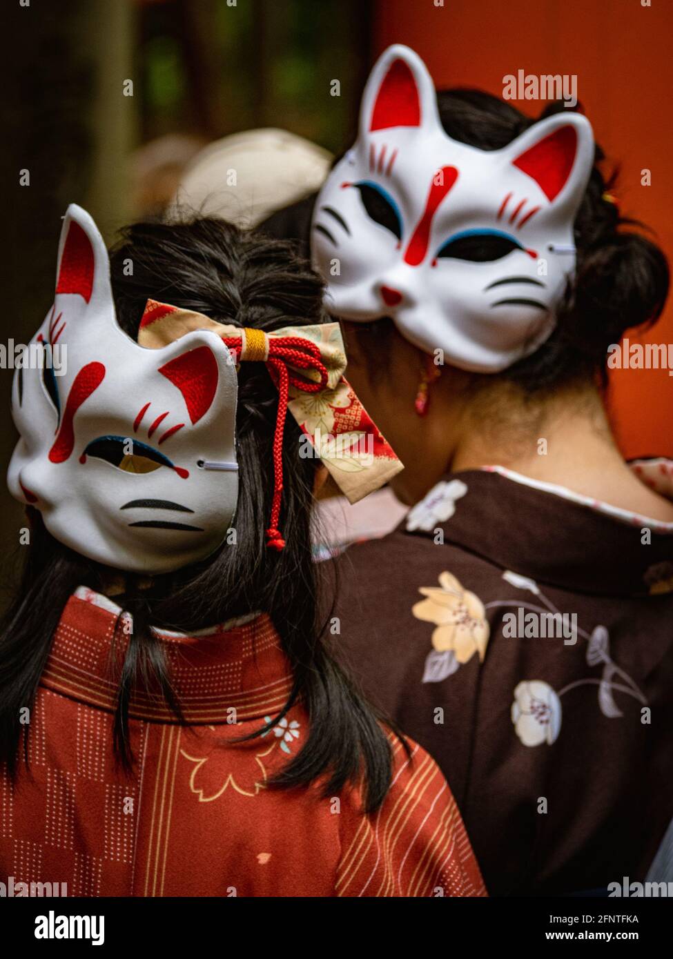 Two girls wearing kimono and Japanese fox Inari masks Stock Photo - Alamy