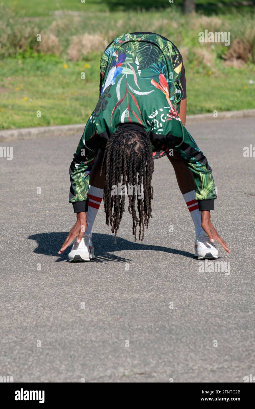 A fit nimble woman in her 50s at a meditative Yoga class in a park in ...
