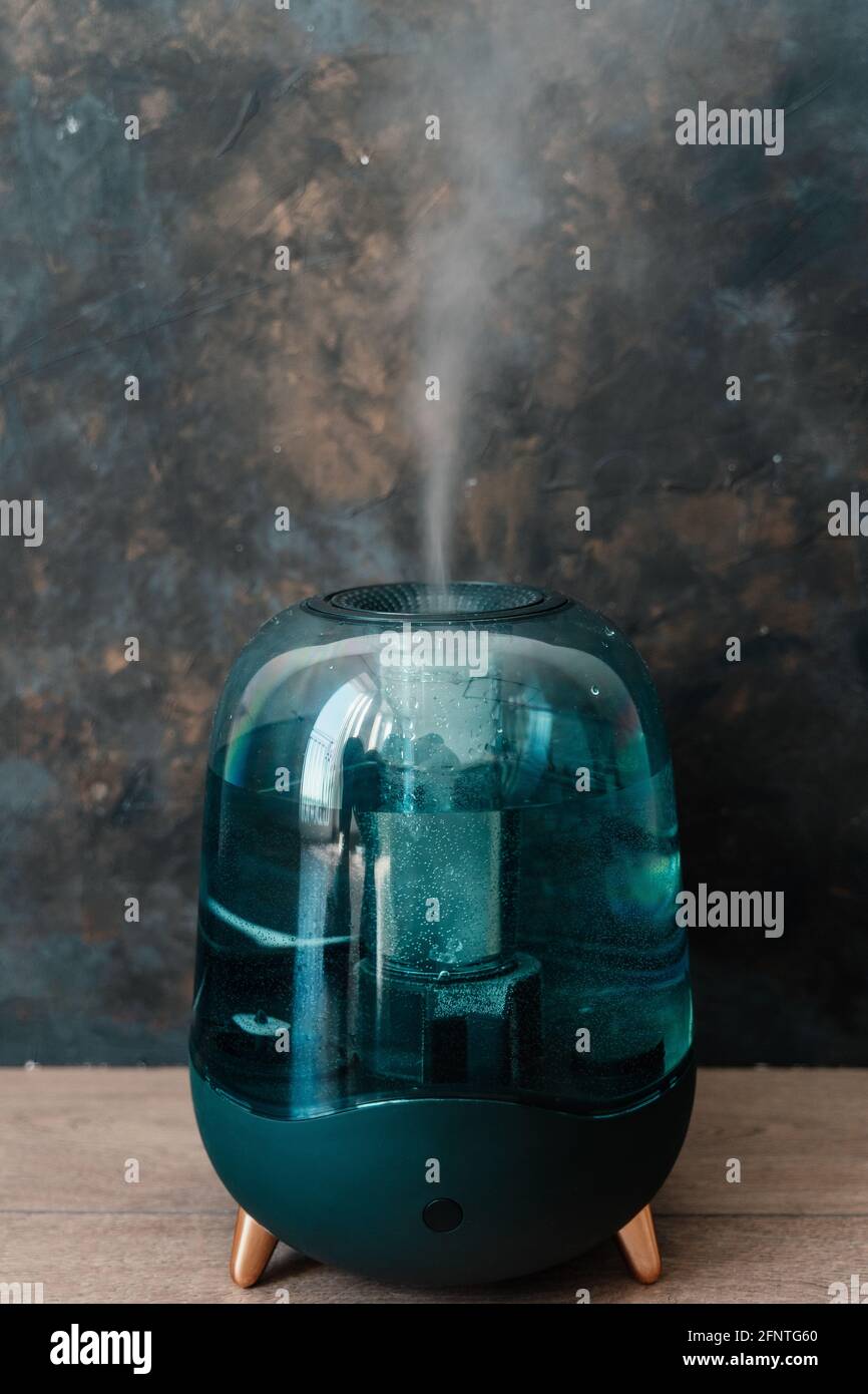 Modern air humidifier on a dark background. Humidifier spreading steam ...