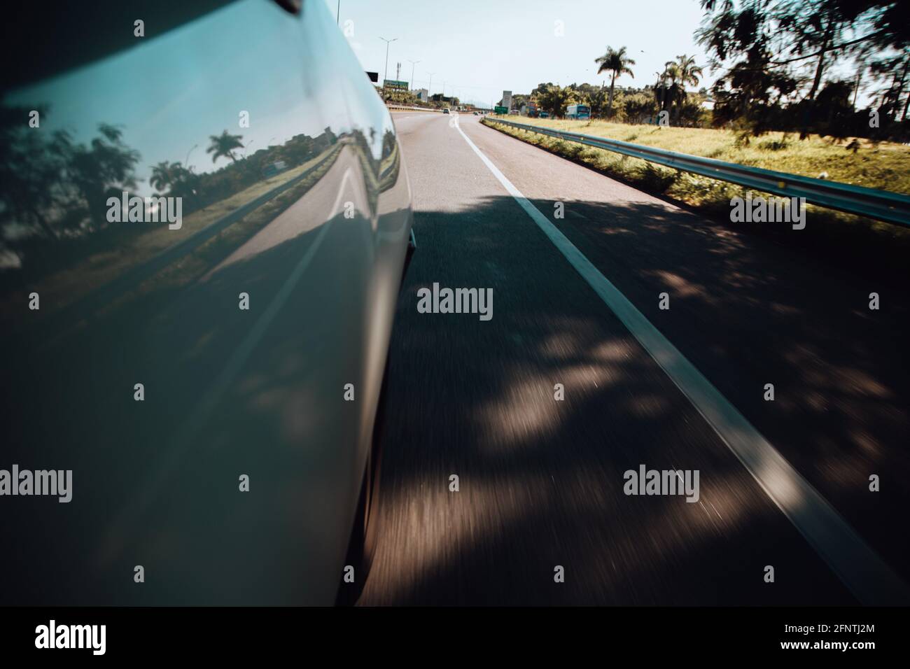 Car driving fast on a highway lined with palm trees Stock Photo - Alamy