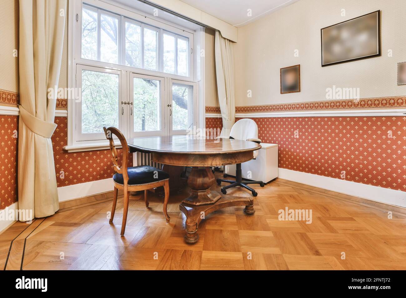 Vintage table with different chairs located near window with curtains ...