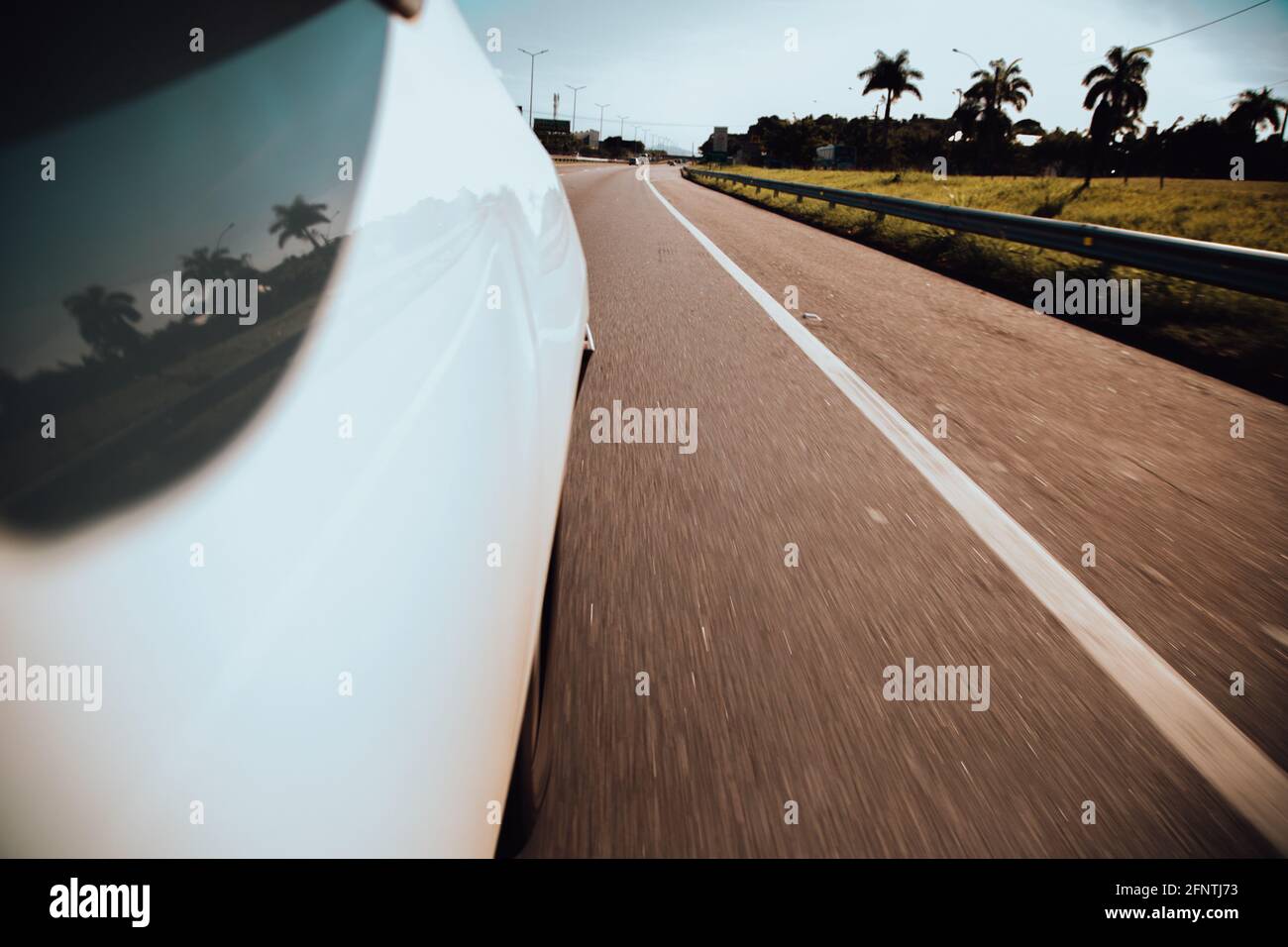 Car driving fast on a highway lined with palm trees Stock Photo - Alamy