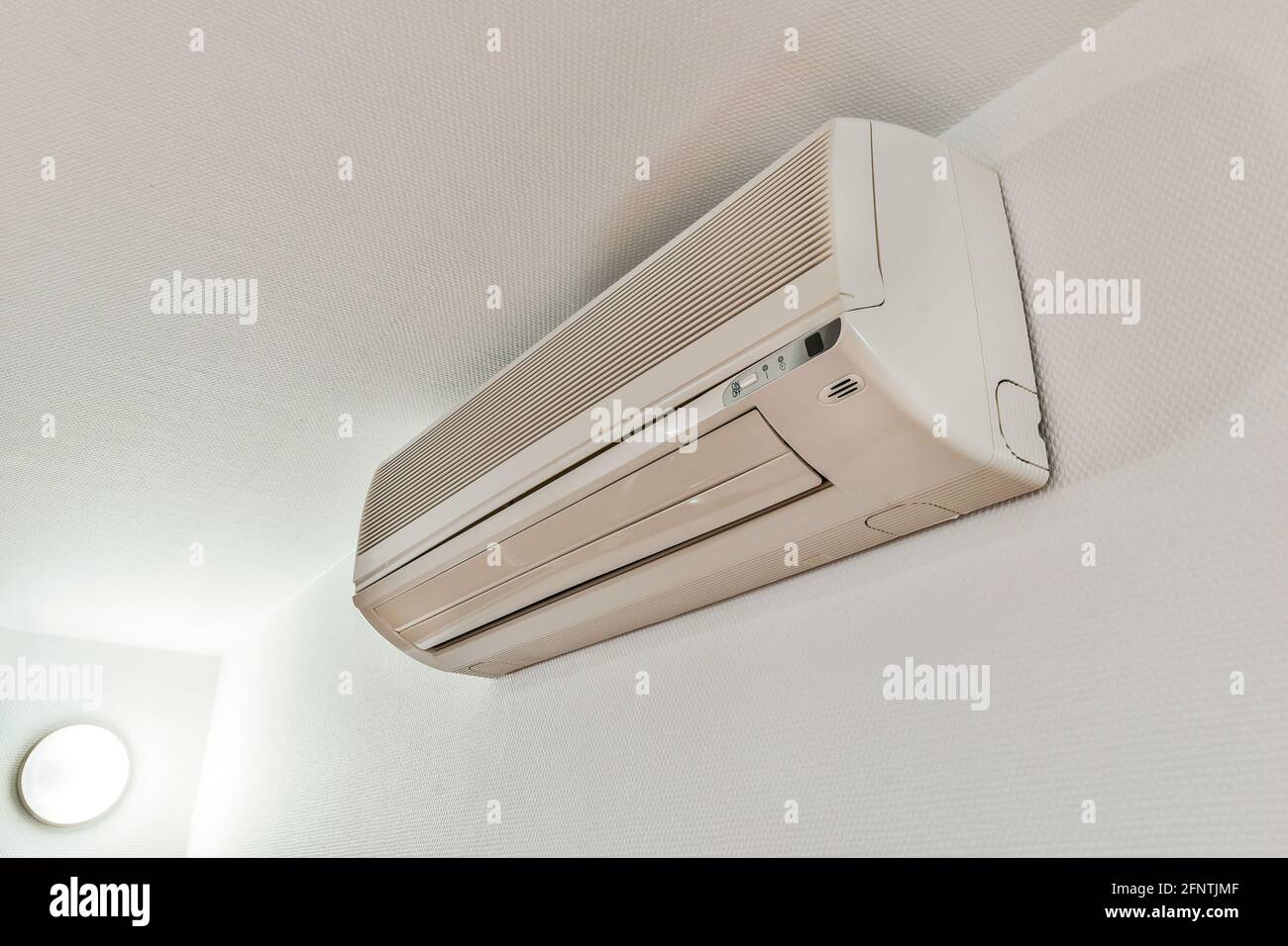 From below modern air conditioner hanging on white wall under ceiling ...