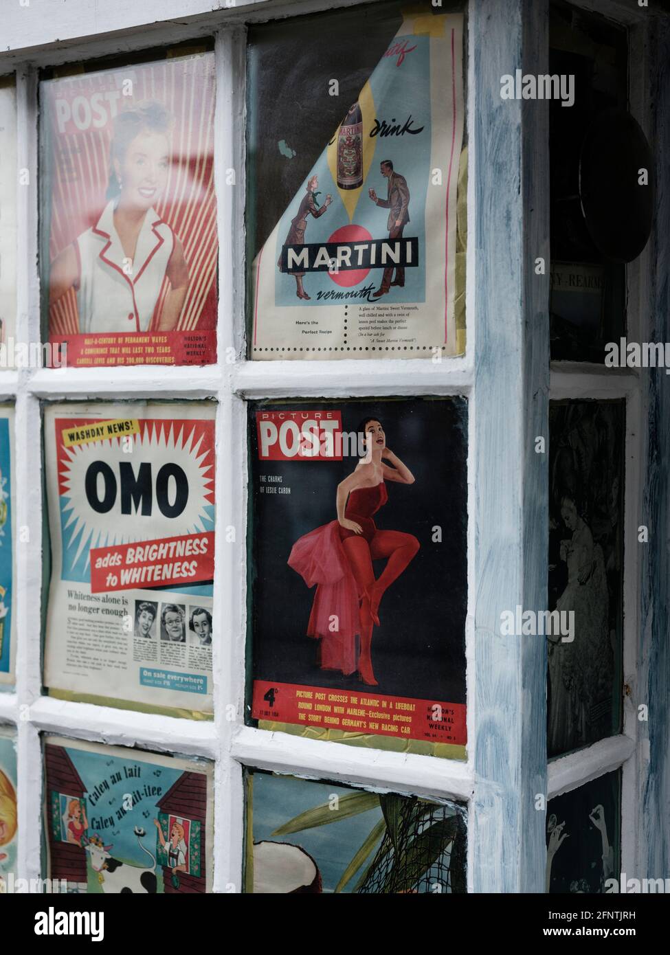 Antique magazines used to cover a shop window in Lyme Regis, Dorset ...