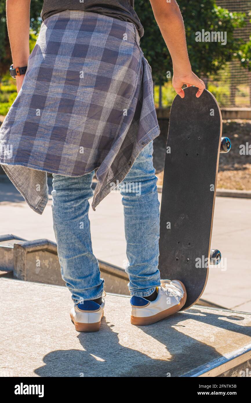 Unrecognizable teenager, photographed from behind, as he prepares to ...