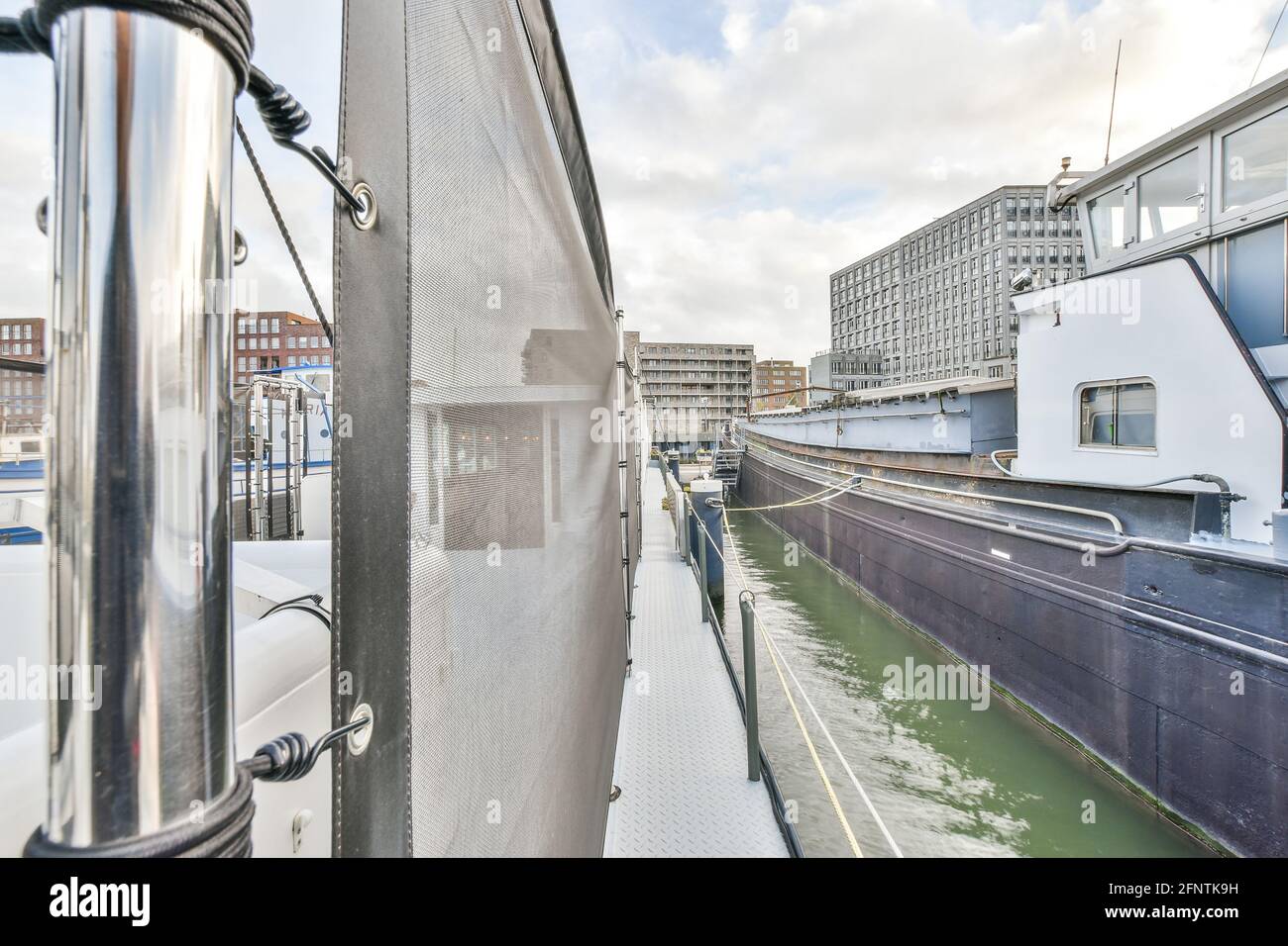 Deck of modern industrial ship floating on river water against cloudy ...