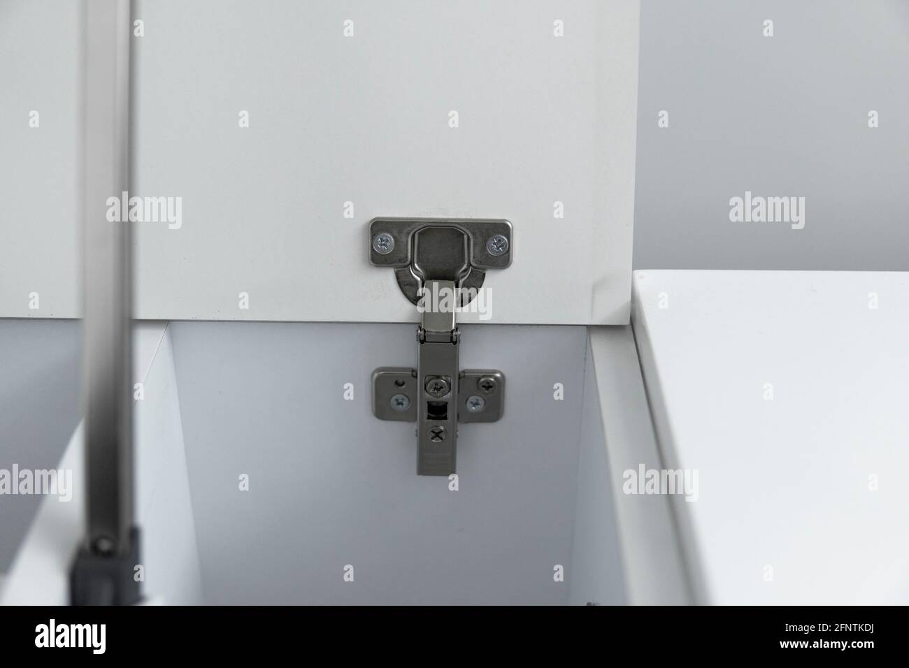 Metallic loop installed in a kitchen cabinet from a white chipboard ...